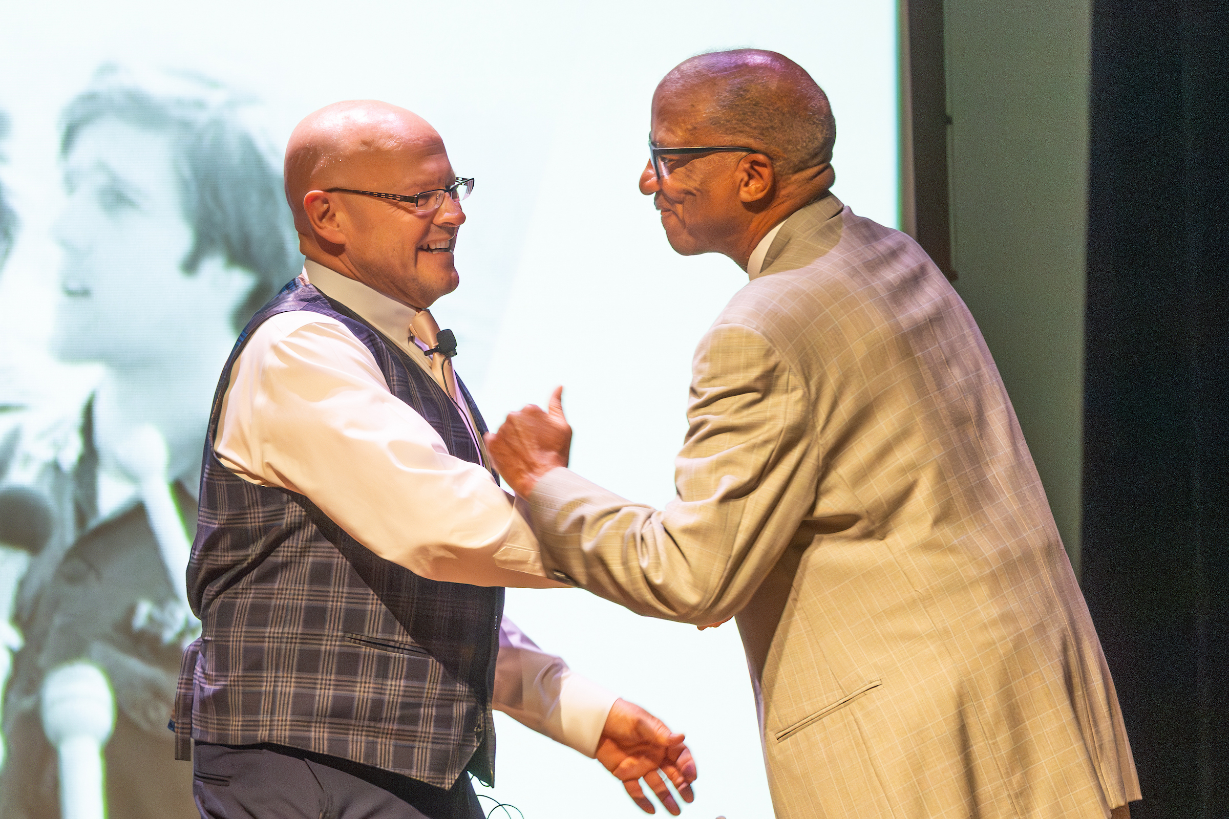 Wil Haygood at his book launch. Two men shake hands and smile on stage ...
