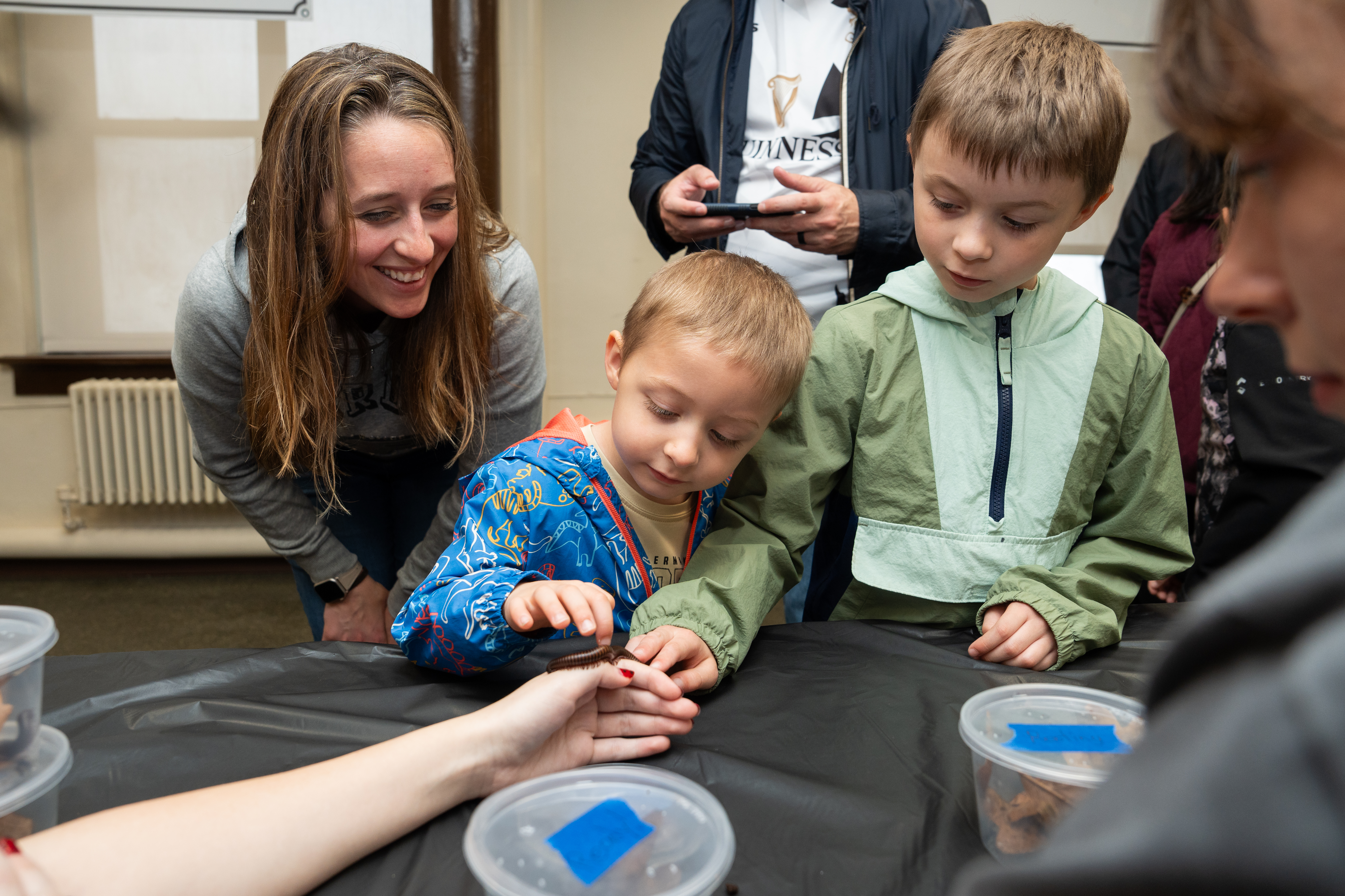 Younger Bug Bowl guests petting millipedes at the live insect petting zoo.