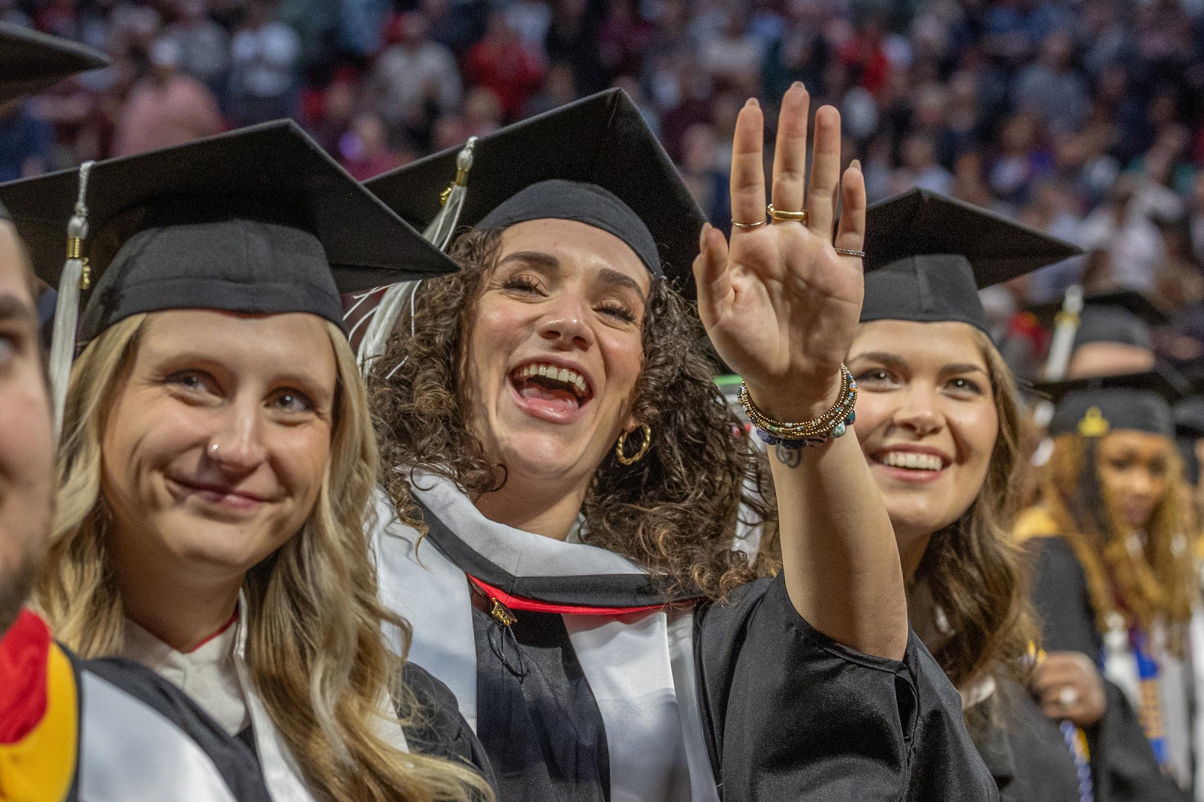 A student waves during the Fall Commencement ceremony at Millett Hall.