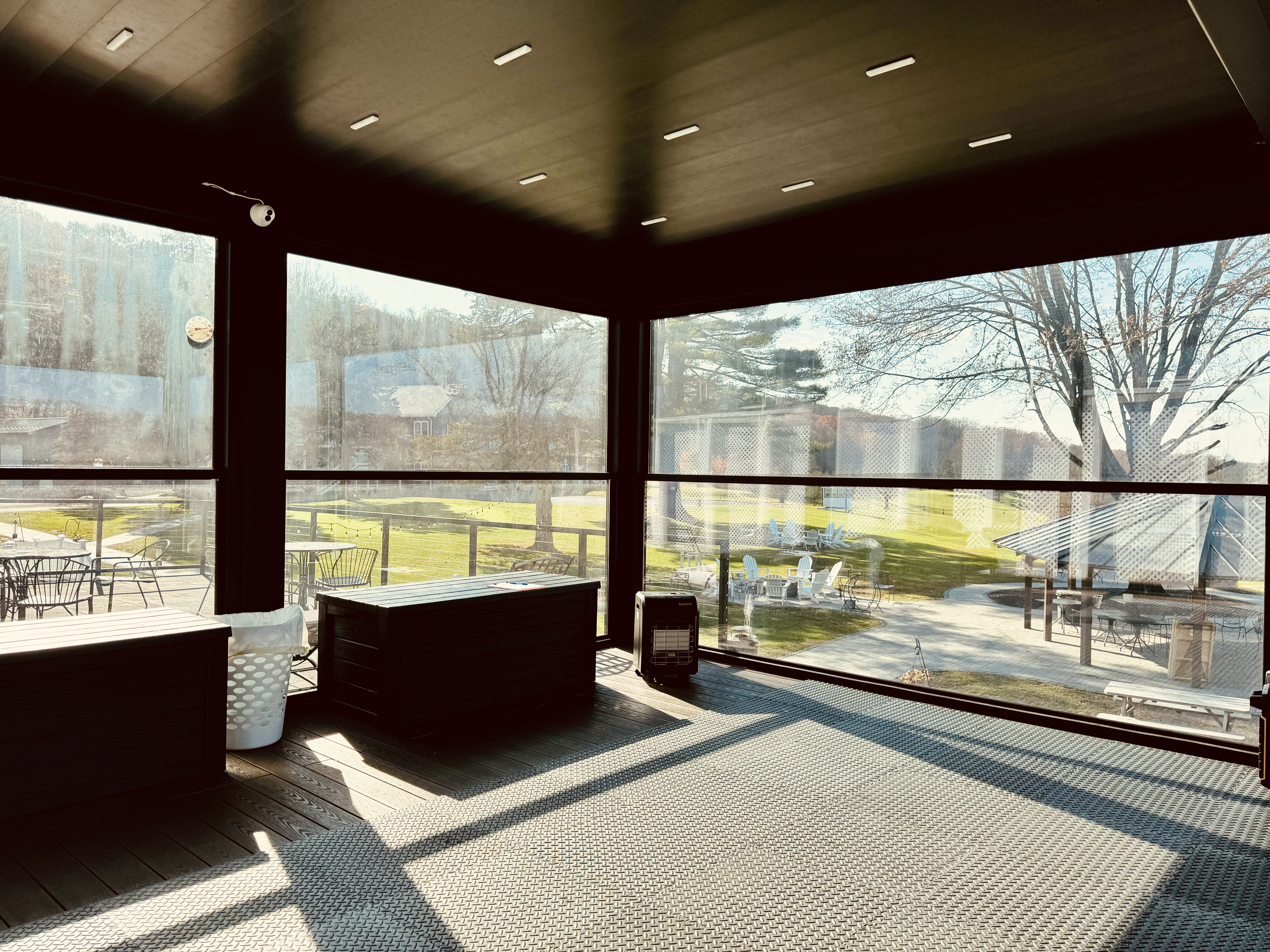 Sunroom with black trim and large windows overlooking a green lawn ...