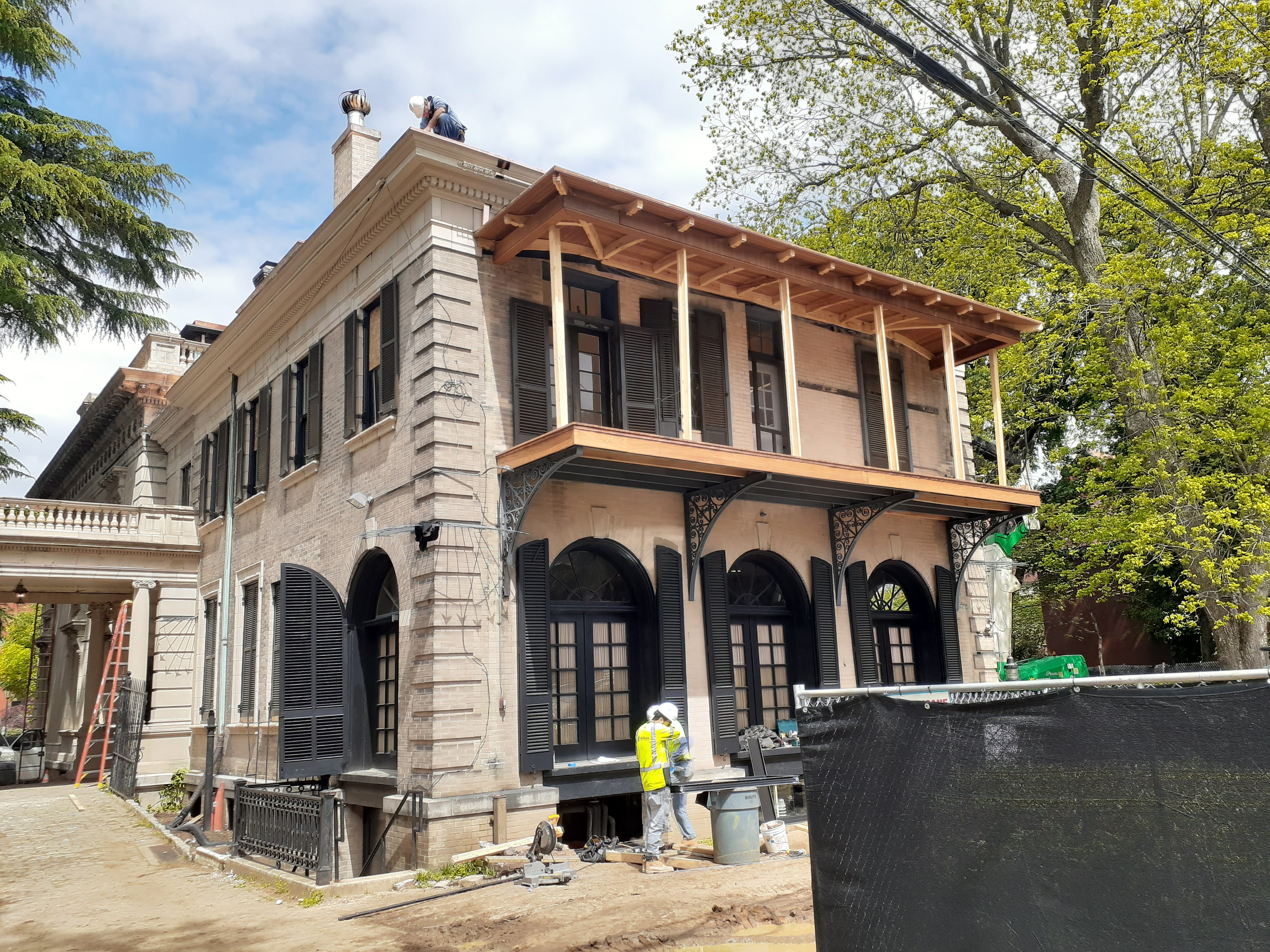 Construction workers rebuilding the back balcony at the Scott House.
