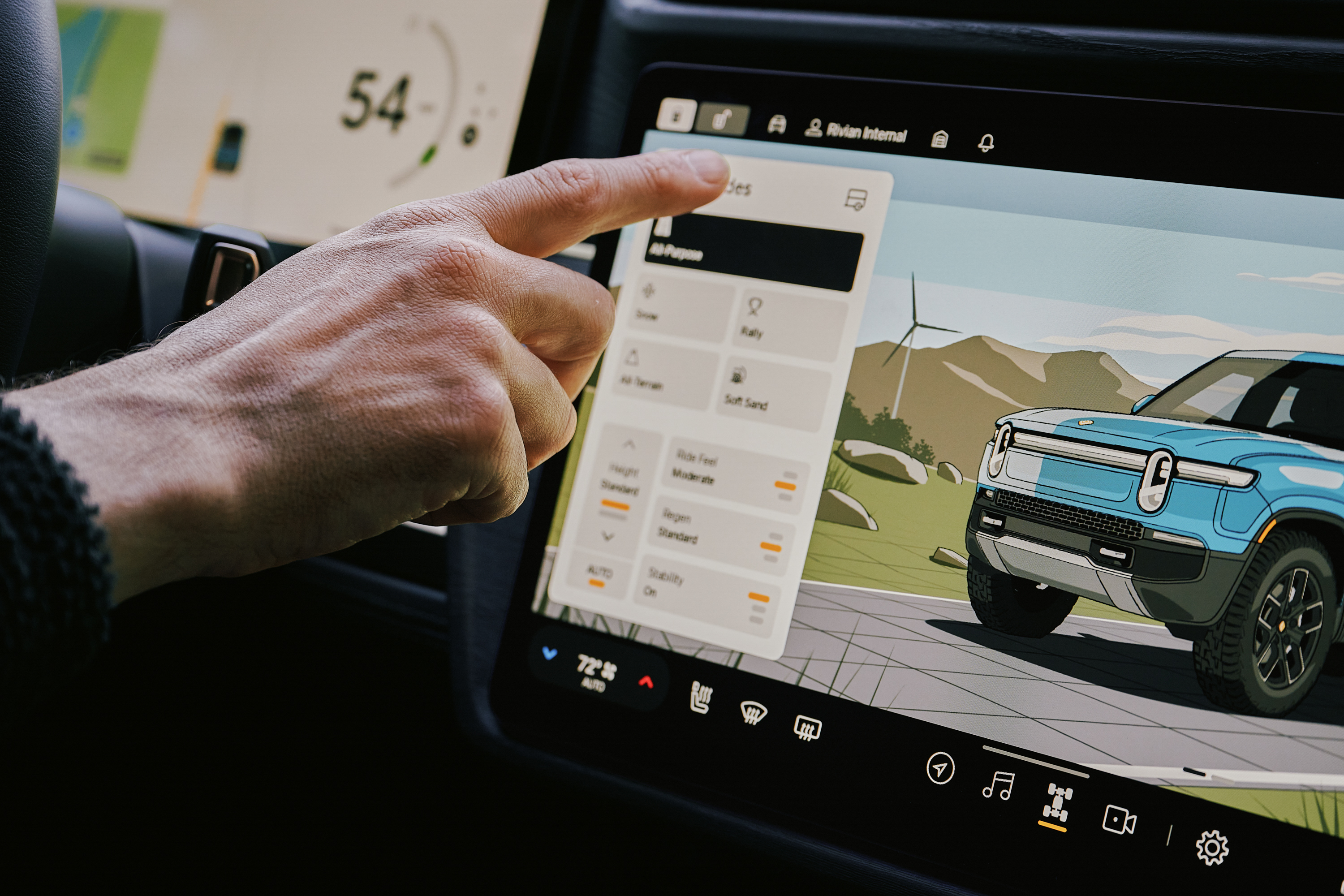 Finger touches a Rivian touchscreen to select drive modes. A cartoon ...