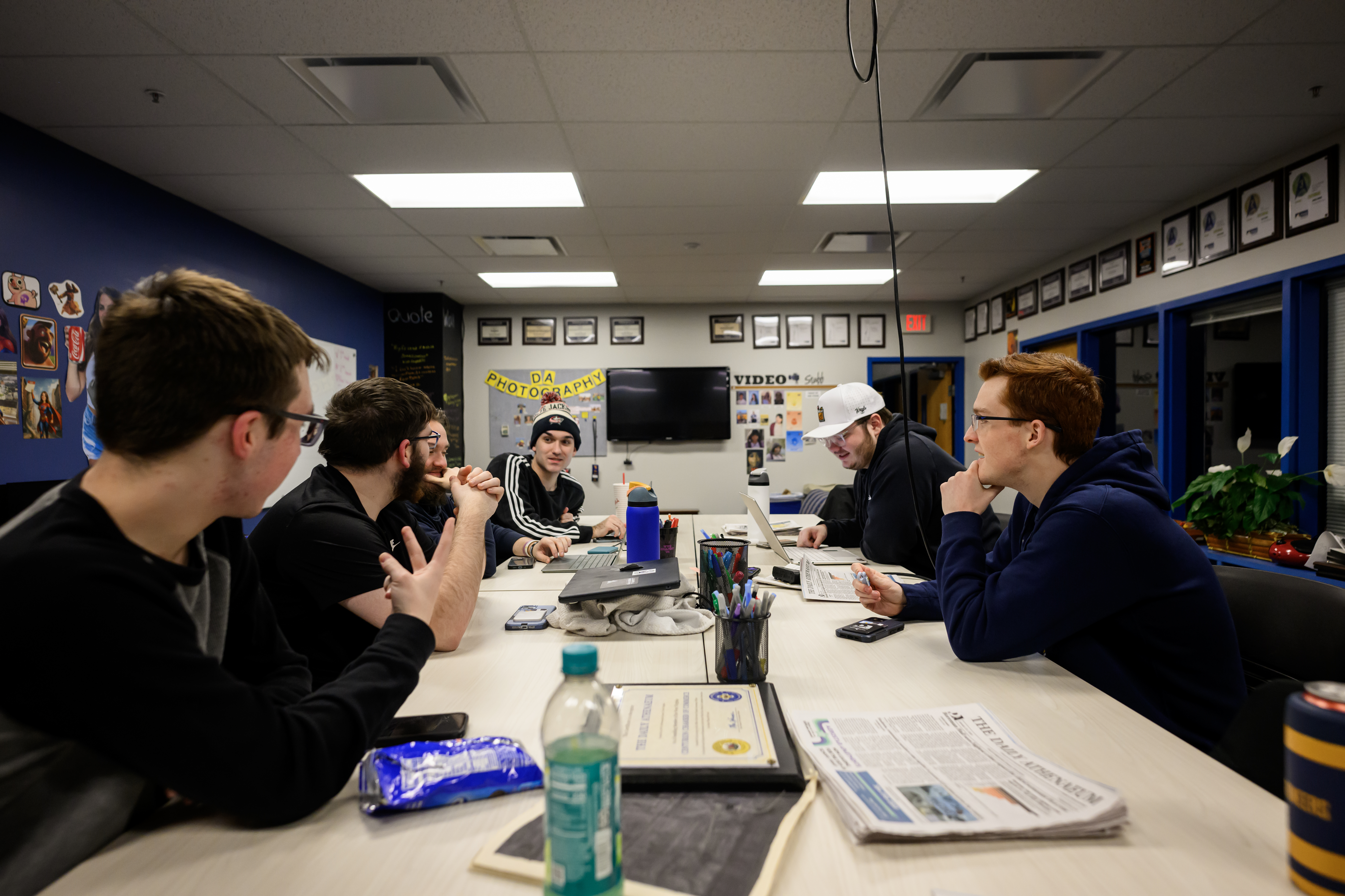 U92 students meet at a table in the Daily Athenaeum office. Students ...