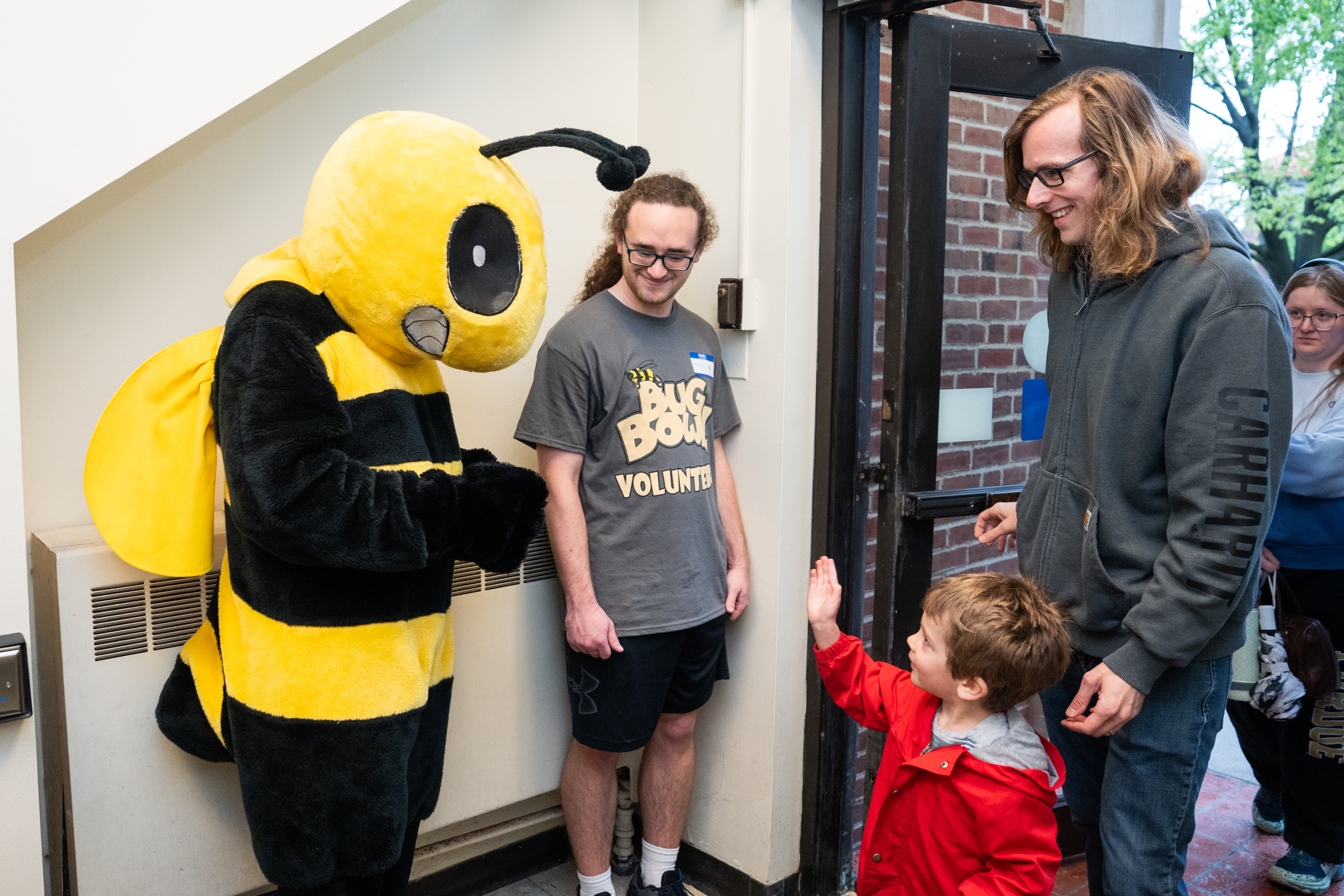 A Bug Bowl volunteer wearing a bee costume greeting guests.