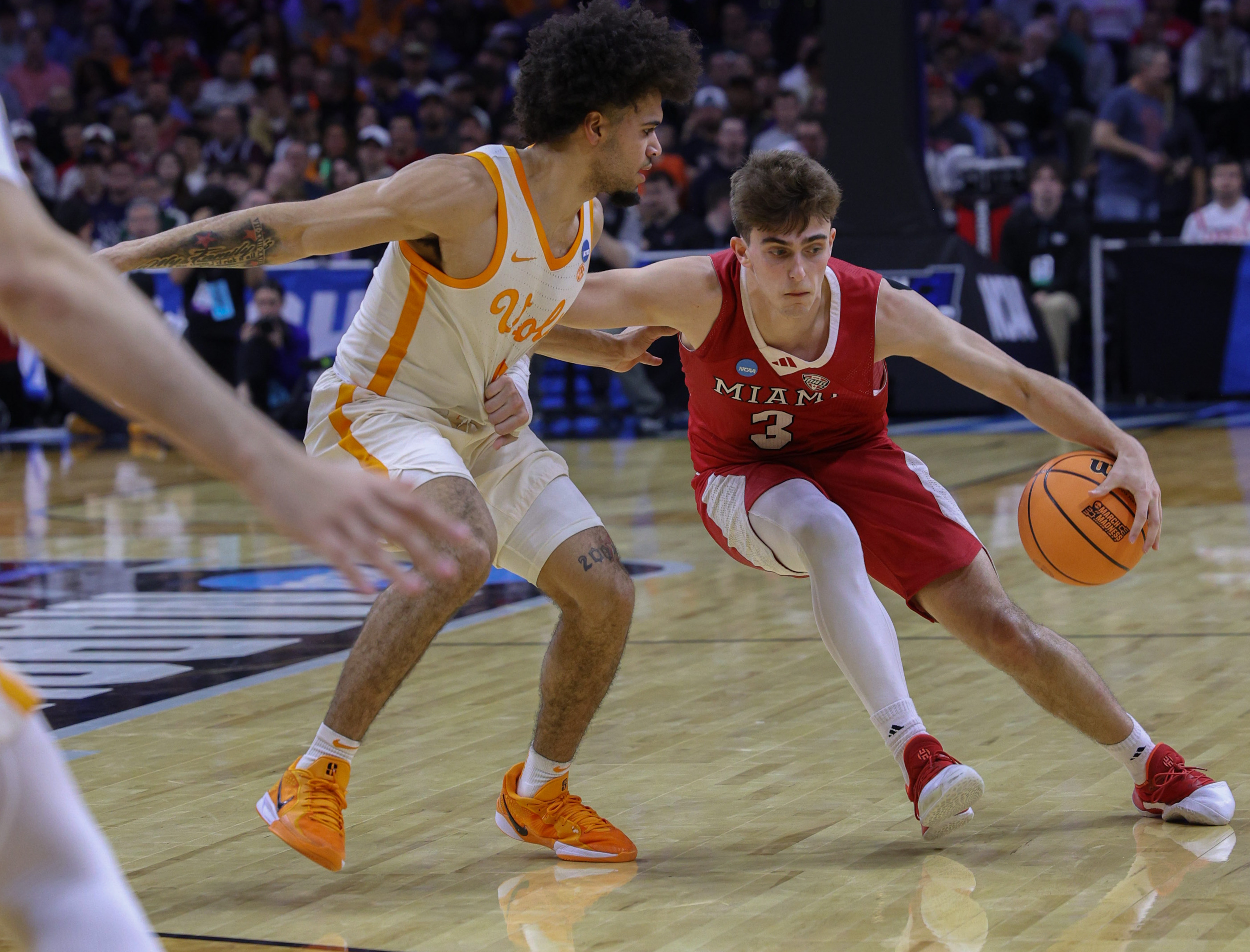 A Miami RedHawks player dribbles the basketball while being guarded ...