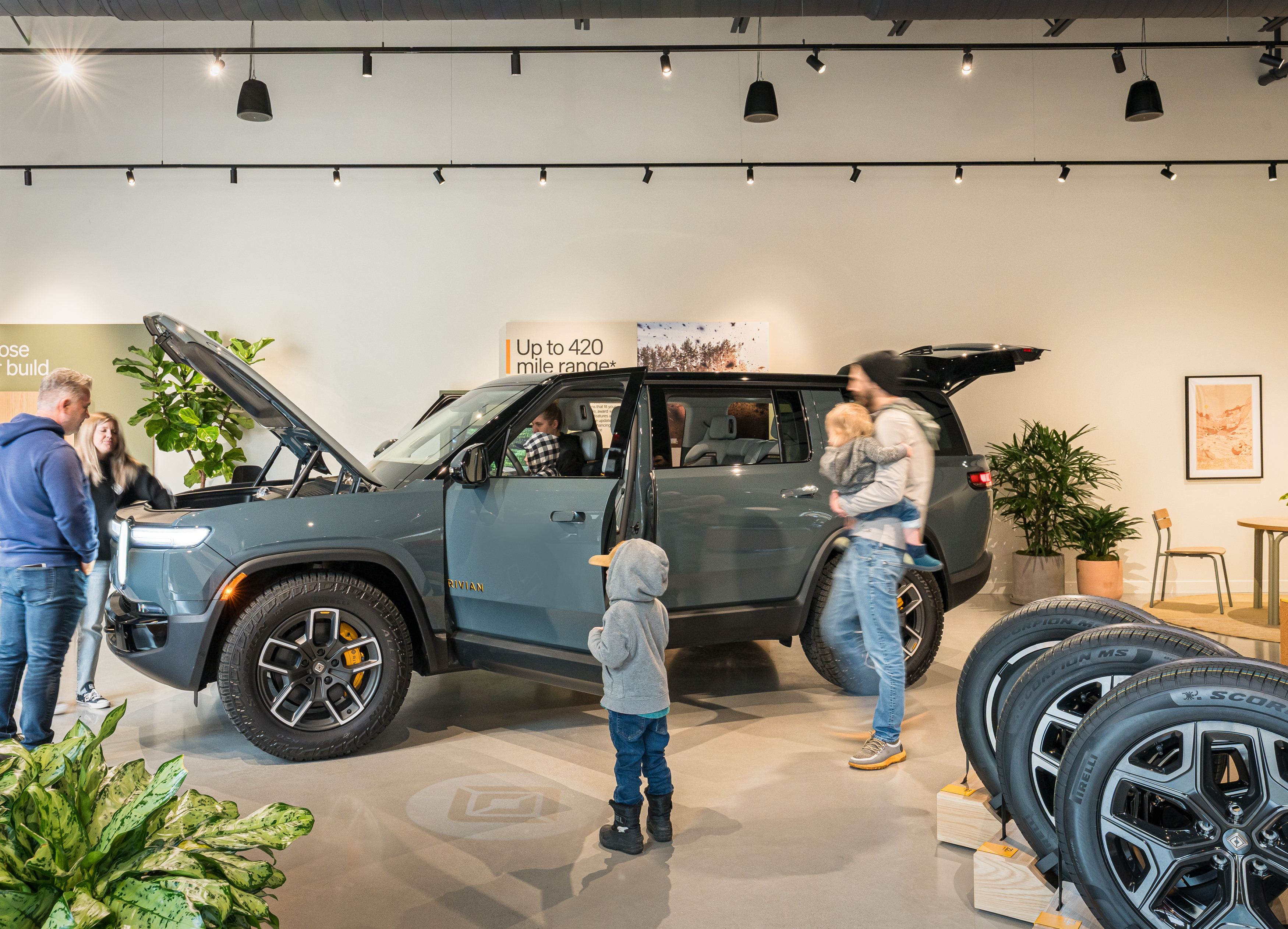 Rivian R1S SUV on display in showroom with hood and rear hatch open ...